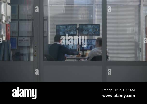 Two security officers control CCTV cameras on computers during lunch ...