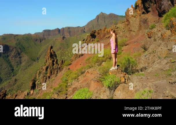 Young girl enjoys the view of the gorge from the top of mountain ...