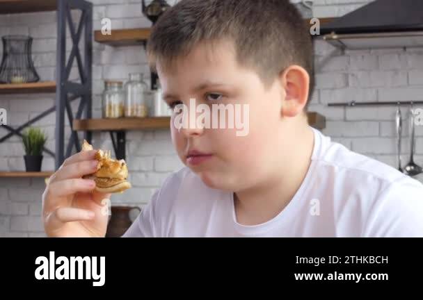 Fat man eats fast food hamberger. Breakfast for overweight people ...