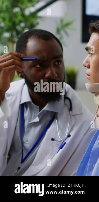Vertical video: Doctor checking patient eye vision during checkup visit ...