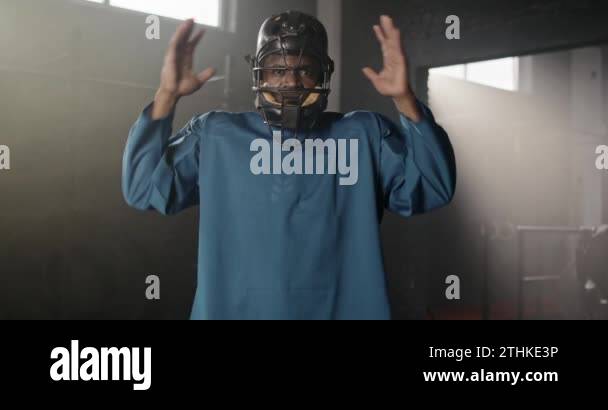 Good-looking African American football captain standing straight in ...
