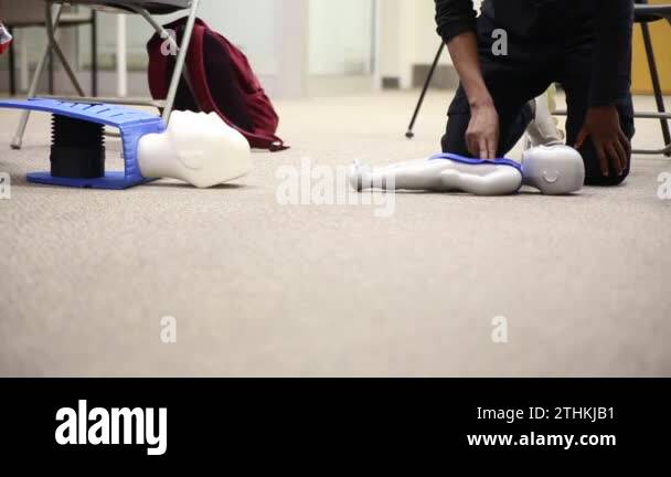 Staff is training to conduct first aid CPR with a dummy doll and AED ...