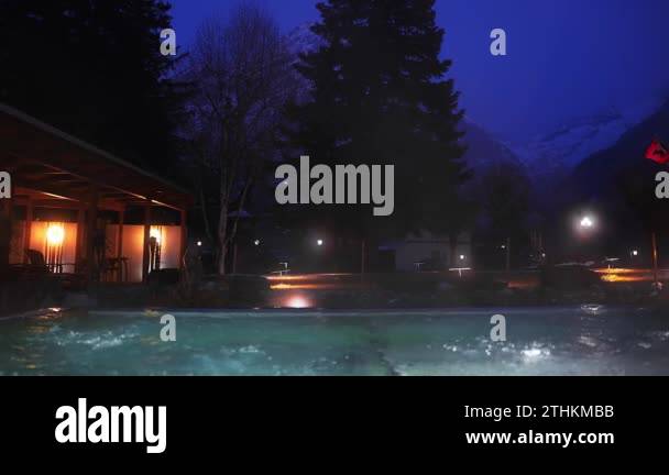 Evening by the infinity pool in Grindelwald, Switzerland. Luxury winter ...