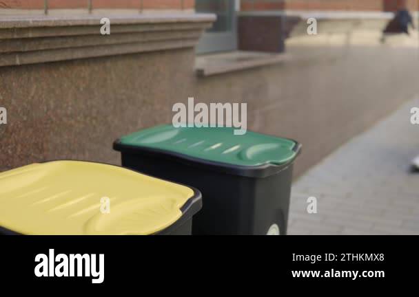 Close view of the sorting bin and the male hands in gloves puts two ...