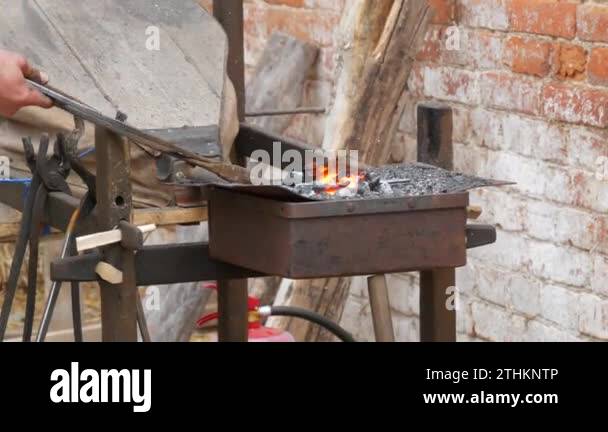 Medieval method of forging iron, the blacksmith forges an iron nail ...