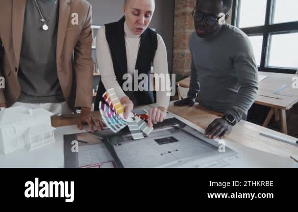 Tracking out slow mo of three multiethnic female and male designers ...