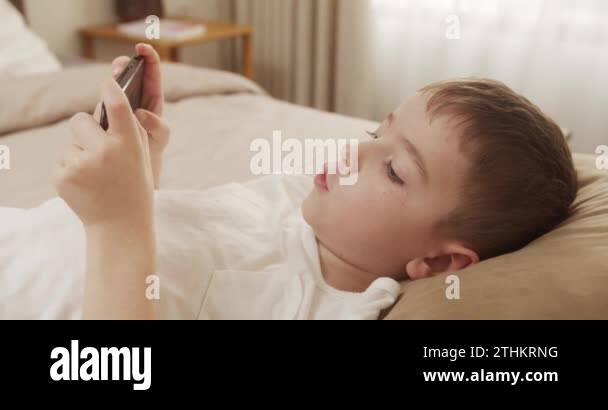 Beautiful child boy 6 years old playing mobile game on smartphone at ...