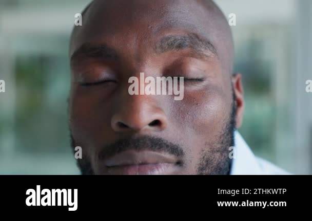 Handheld view of serious, thinking man and opening his eyes in an ...
