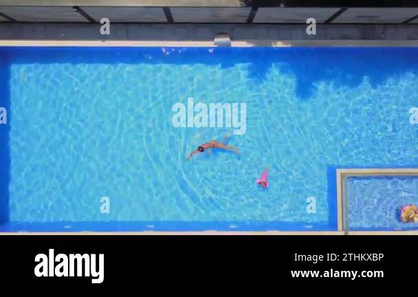 Young mother swims in pool with her child. View from drone in pool in ...