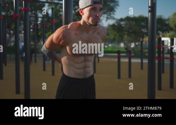 Athletic man stretching body holding crossbar on modern calisthenics ...