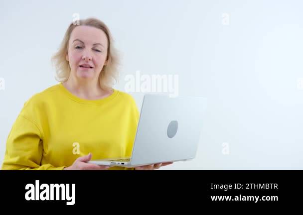 Discontented woman swears at broken or slow computer seated at desk ...