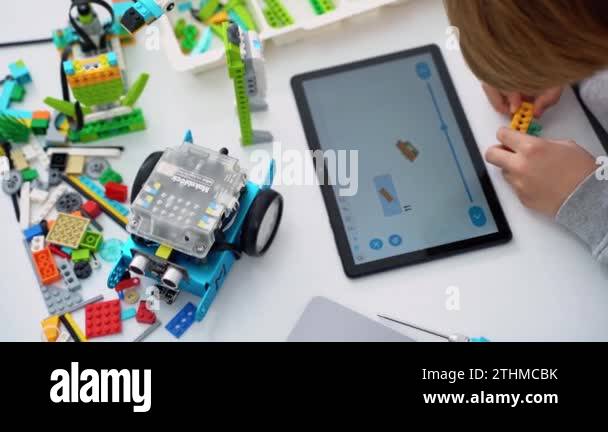 Robotics programming class. Children construct and code Robot. STEM education using constructor ...