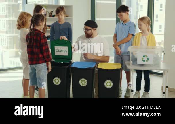 Garbage sorting lesson, a young male teacher tells and explains to ...