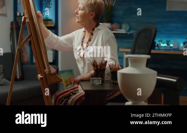 Portrait of senior woman using vase inspiration to draw artwork sketch ...