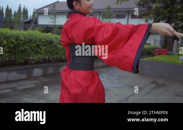 A Chinese Kids in a red costume having fun while playing with the rope ...