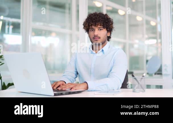 Young surprised puzzled worker spreads hands, shrugs shoulders looking ...