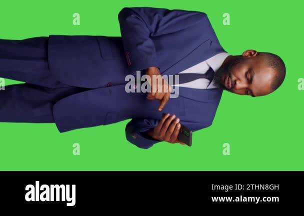Vertical video: Front view of corporate worker talking on mobile phone ...