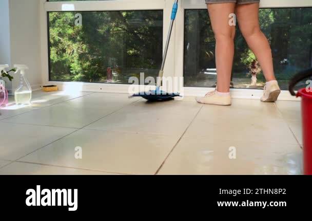 Details: legs of a housewife or maid mopping the floor in the house ...