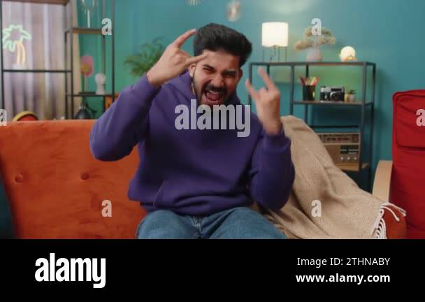 Overjoyed indian man showing rock n roll gesture by hands, cool sign ...