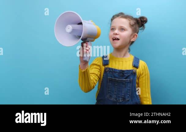 Pretty little girl talking with megaphone, proclaiming news, loudly ...