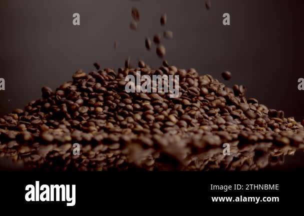 Coffee beans pouring on top heap close up. Roasted caffeine grains ...