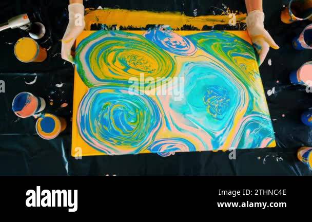 Fluid art technique. Female artist works on abstract fluid art painting ...