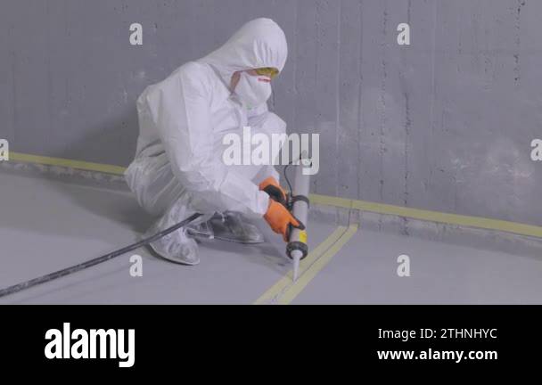 The builder covers the joint seam with sealant. Construction worker ...
