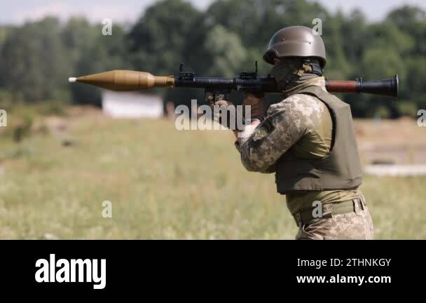 The soldier wears a helmet, military uniform, and body armor while ...