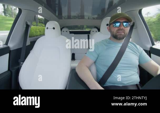 Mature male driver inside Tesla Model Y car using self drive autopilot ...