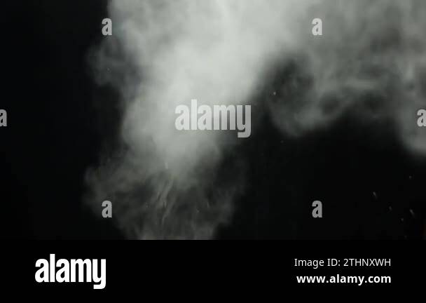 Throwing flour on a black background. White dust explosion effect. For ...