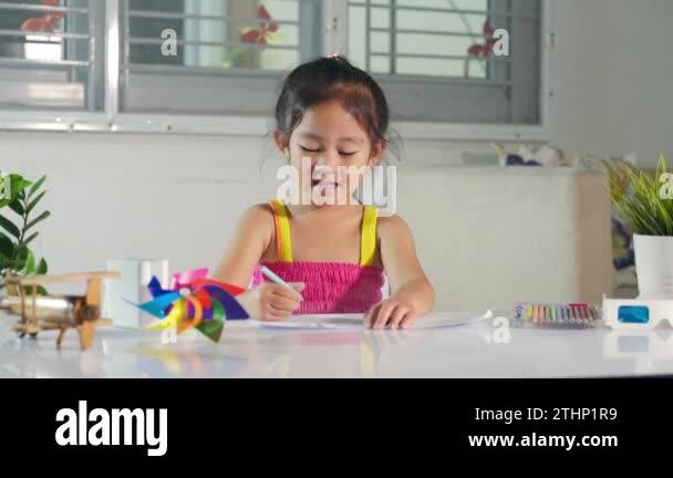 Child little girl drawing cartoon on paper before paint the color ...