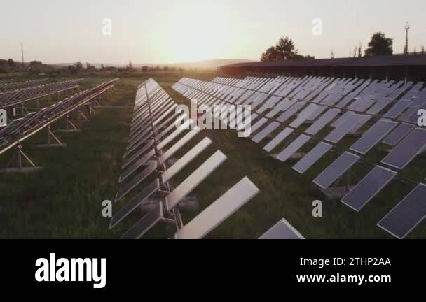 At sunset taking video at solar panels farm group of engineers and ...