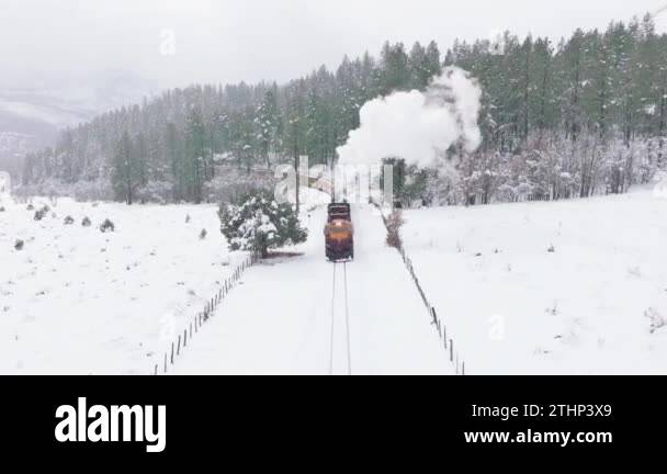 Steam locomotive arrives on to the train station, aerial 4K landscape ...