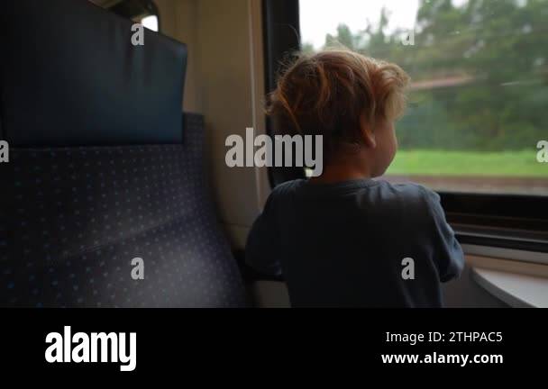 Child standing by train window looking out through window Stock Video ...