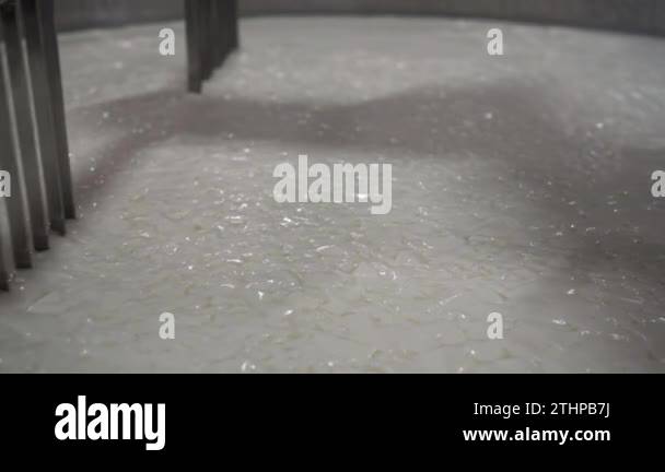 Whey and curd mixing in tank at cheese factory. Tank full with ...