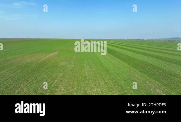Tractor with a roller tillage on spring field, aerial 4k video. Soil ...