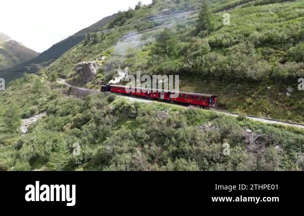 An old steam locomotive runs over a cogwheel railroad mountain route in ...