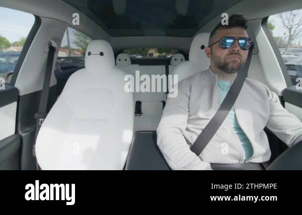 Mature male driver inside Tesla Model Y car using self drive autopilot ...