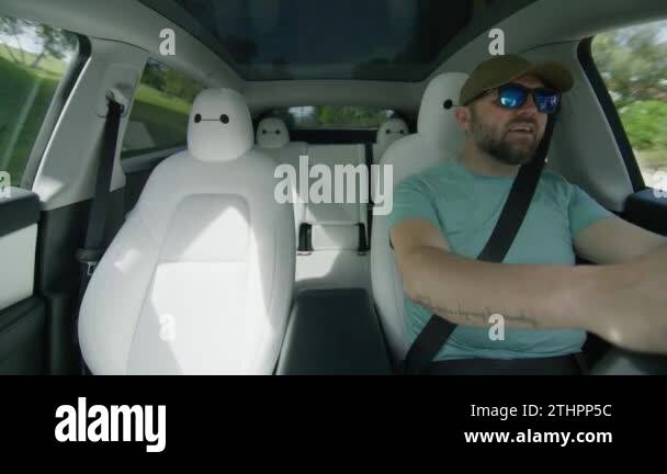 Mature male driver inside Tesla Model Y car using self drive autopilot ...