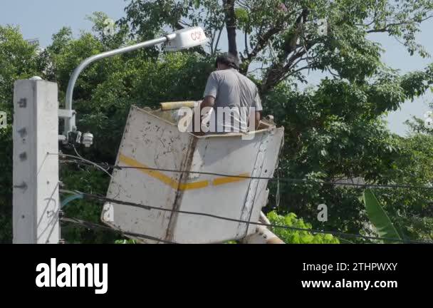 Worker on height lifting platform installing new street light bulb ...