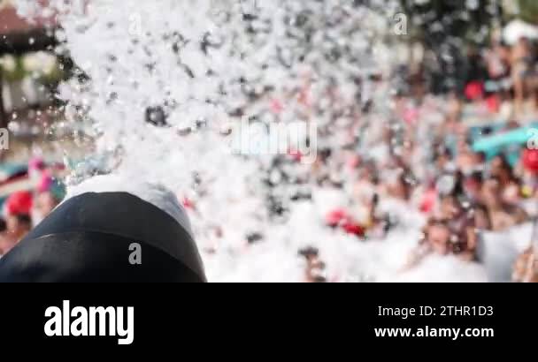 Foam party and dancing on water in pool. Girls and boys have fun and ...