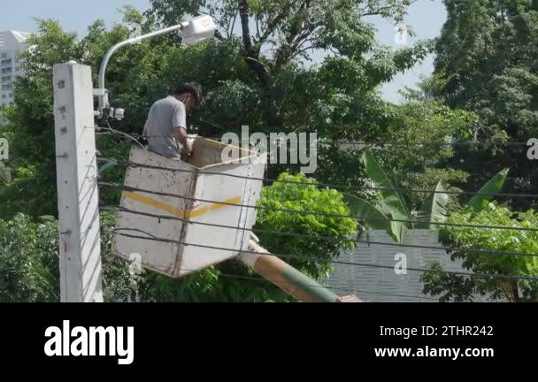 Worker on height lifting platform installing new street light bulb ...