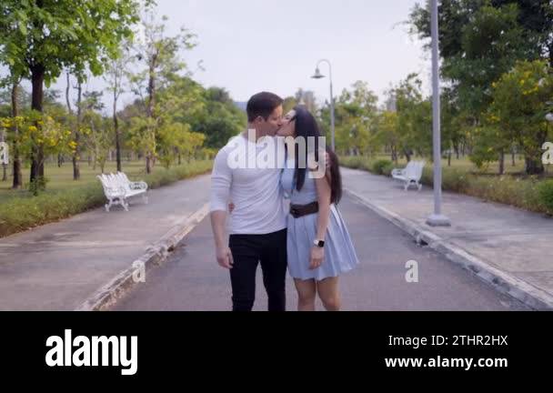 Interracial couple in romantic walk around the park and kissing. Birds ...