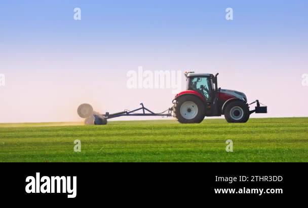 Tractor with a roller tillage on spring field, aerial 4k video. Soil ...