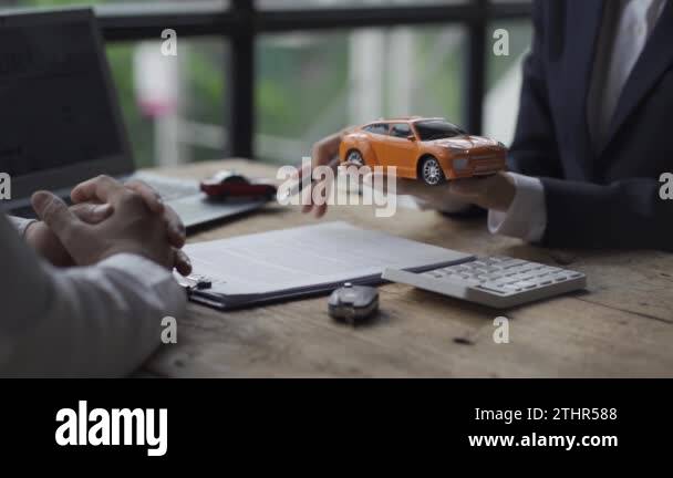 A car salesman in a stylish suit offers successful businessmen a choice ...