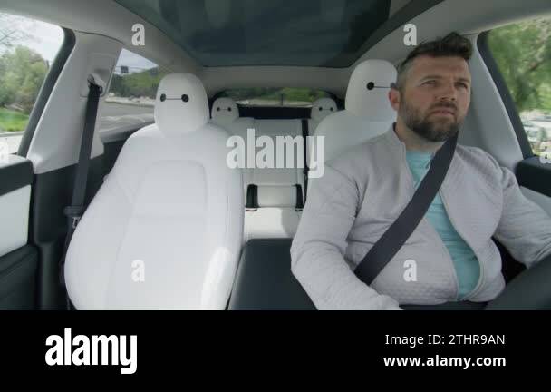 Mature male driver inside Tesla Model Y car using self drive autopilot ...