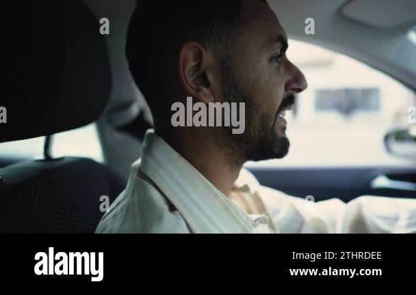 One happy Middle Eastern man driving car. Inside perspective of a male ...