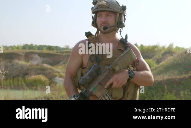 Armed brutal muscular shirtless man in a military uniform holding gun ...