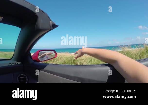 SLOW MOTION CLOSE UP: Driving in cabrio car, hand playing with wind in ...