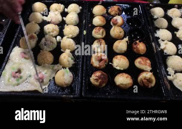 Chef hand pick up Japanese snack food takoyaki from takoyaki pan ...